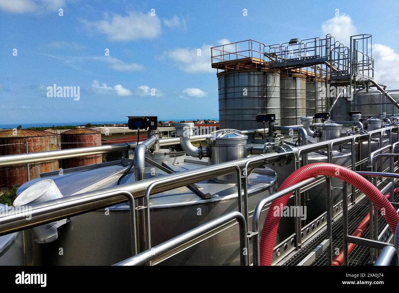 A view of multiple large tanks and metal pipes at a factory Stock Photo ...