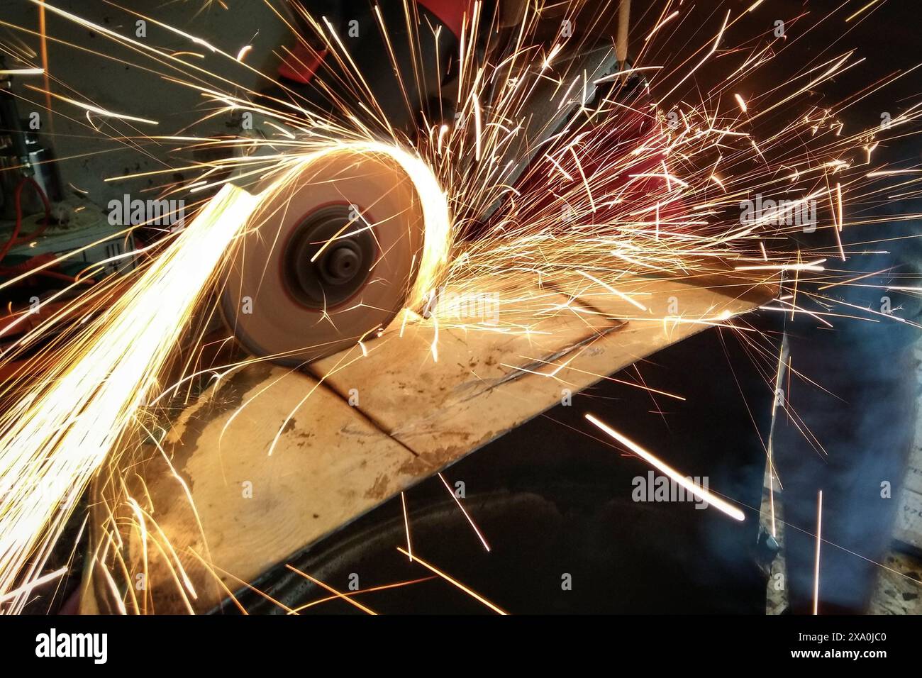 An individual operating a metal cutting machine in a manufacturing ...