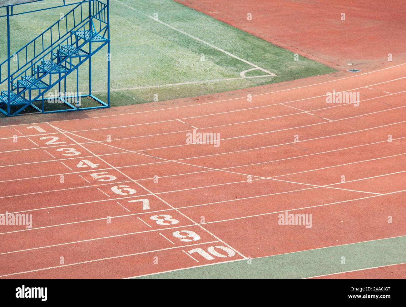 A young student doing long-distance running on a red university track ...
