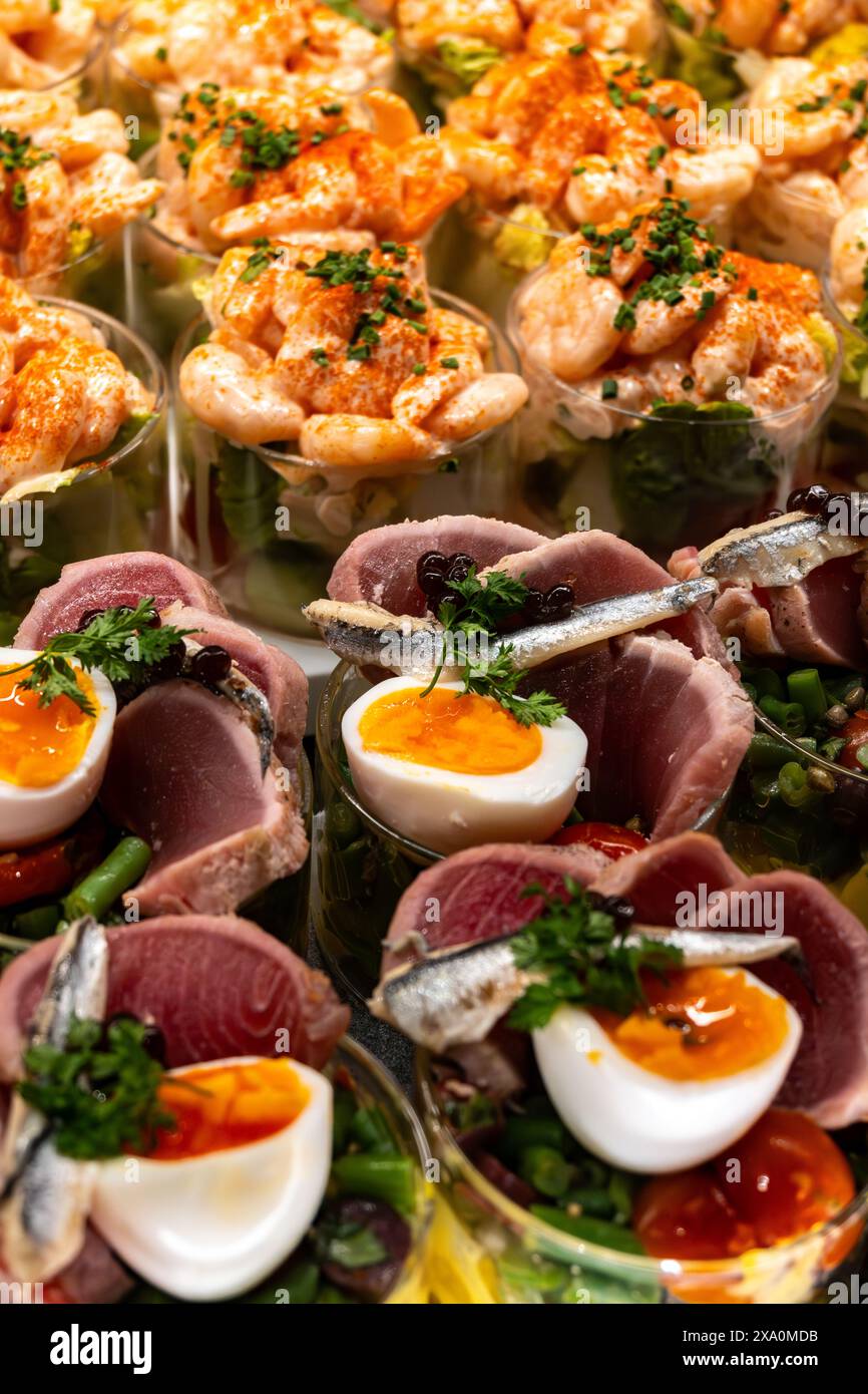 Fancy appetisers in glasses made with deafood, tuna fish, eggs ...