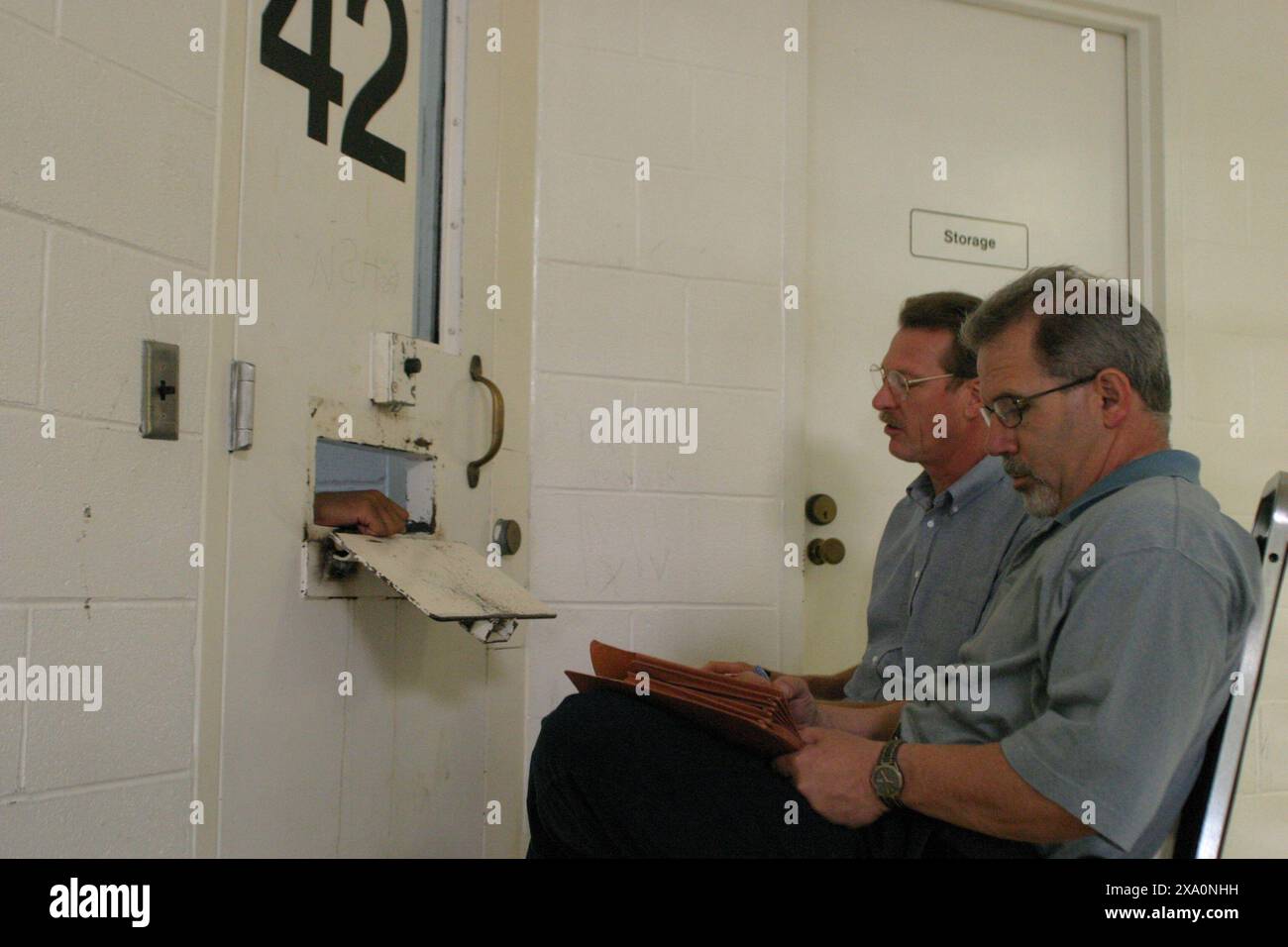 Two male individuals are seen sitting in a prison cell, reading ...