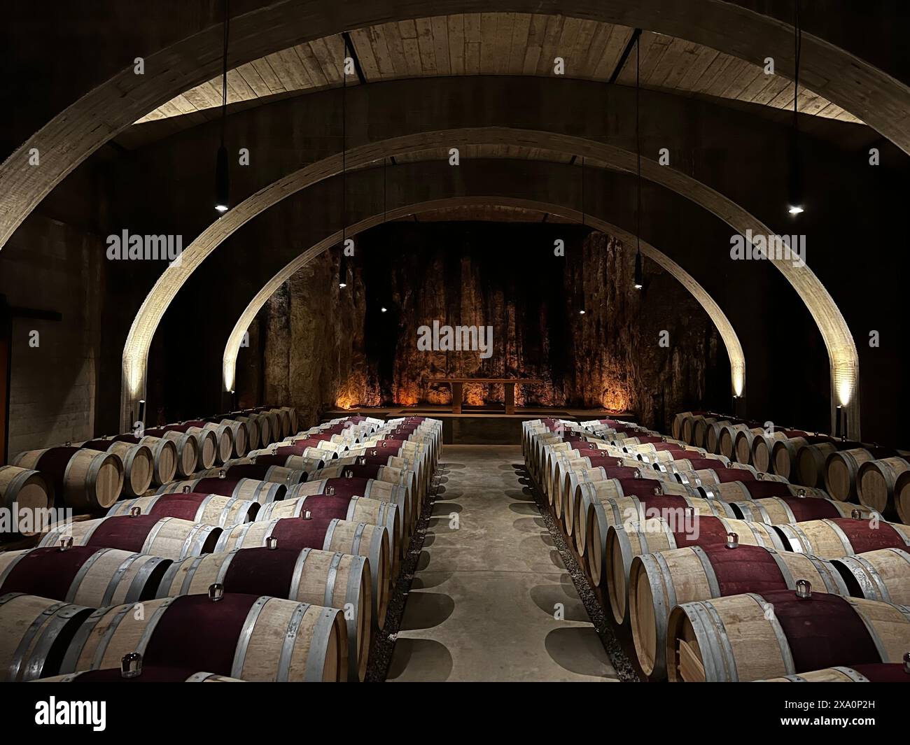 A room filled with wooden wine barrels beside cement columns Stock ...