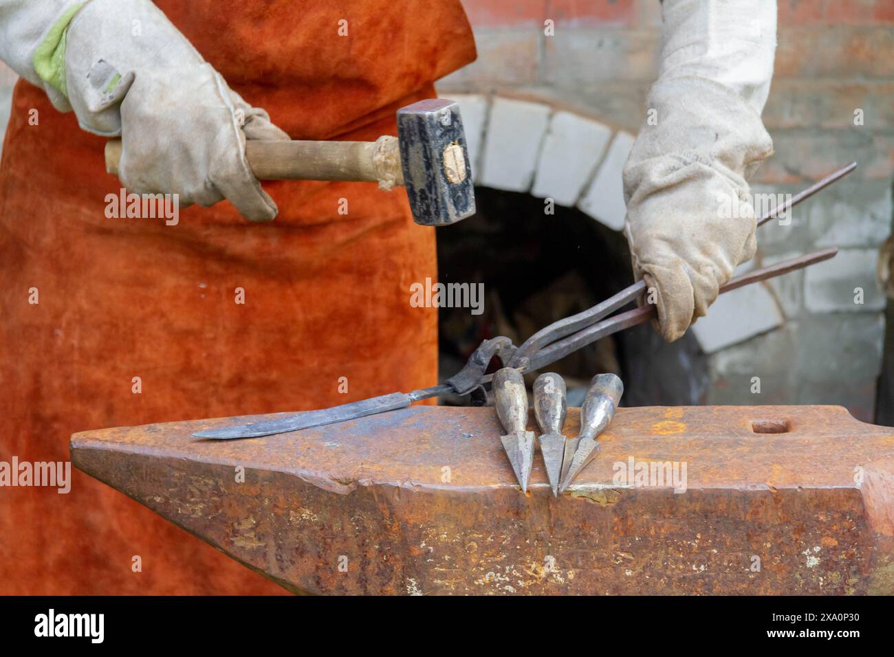 A blacksmith forges iron. Blacksmith's workshop. Blacksmith's anvil and ...