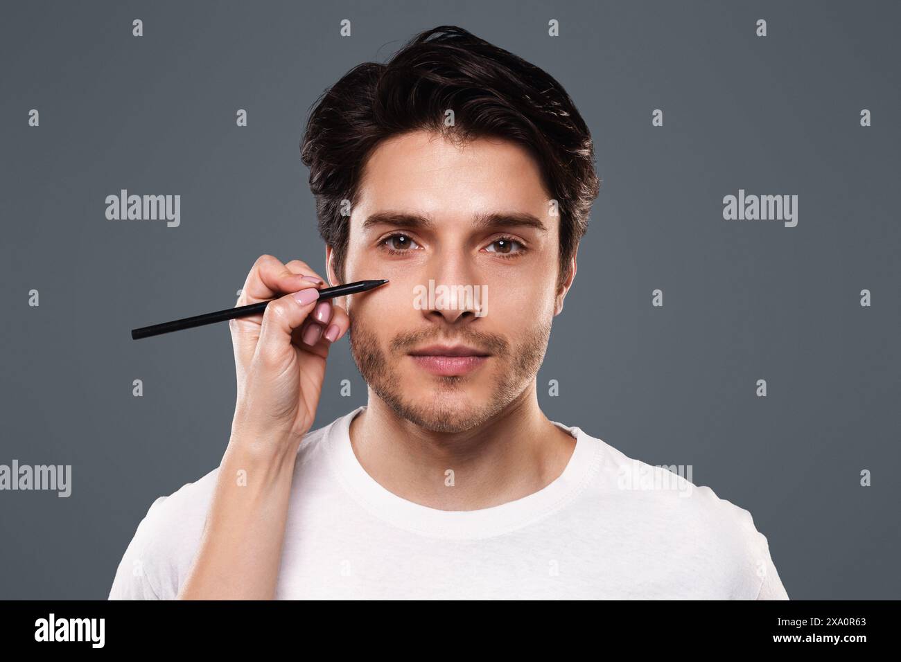 Surgeon drawing marks with pencil on male face Stock Photo - Alamy