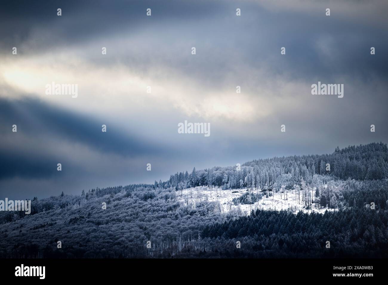 Snow on the ground under dark clouds over sunny mountains Stock Photo ...