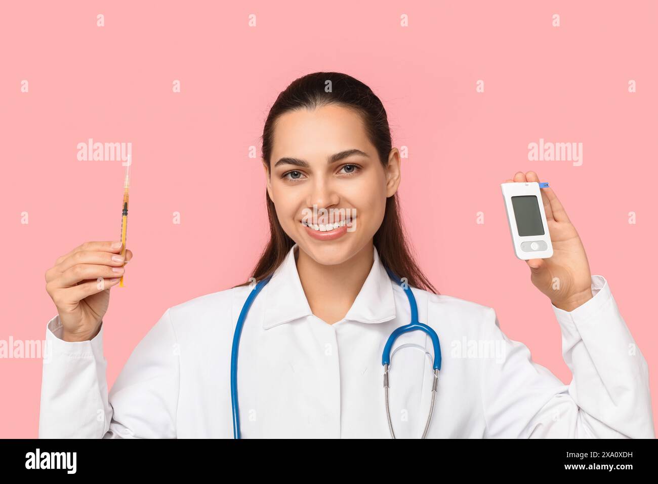 Portrait of female doctor with portable glucose meter and syringe on ...