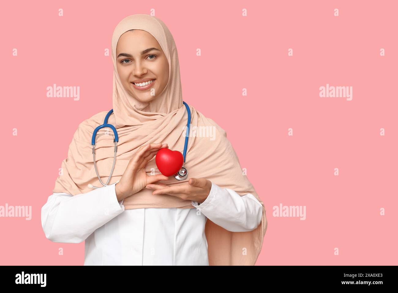 Portrait of female Muslim doctor with heart on pink background Stock ...