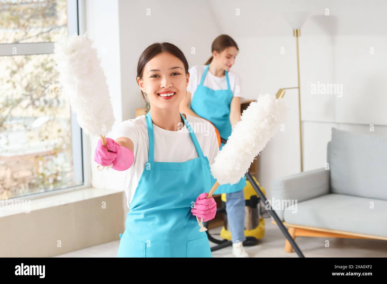 Female Asian janitor with pp-dusters in room Stock Photo - Alamy