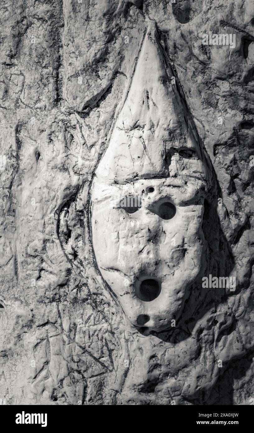 Crude faces caved into the limstone walls of the Hellfire cave complex ...