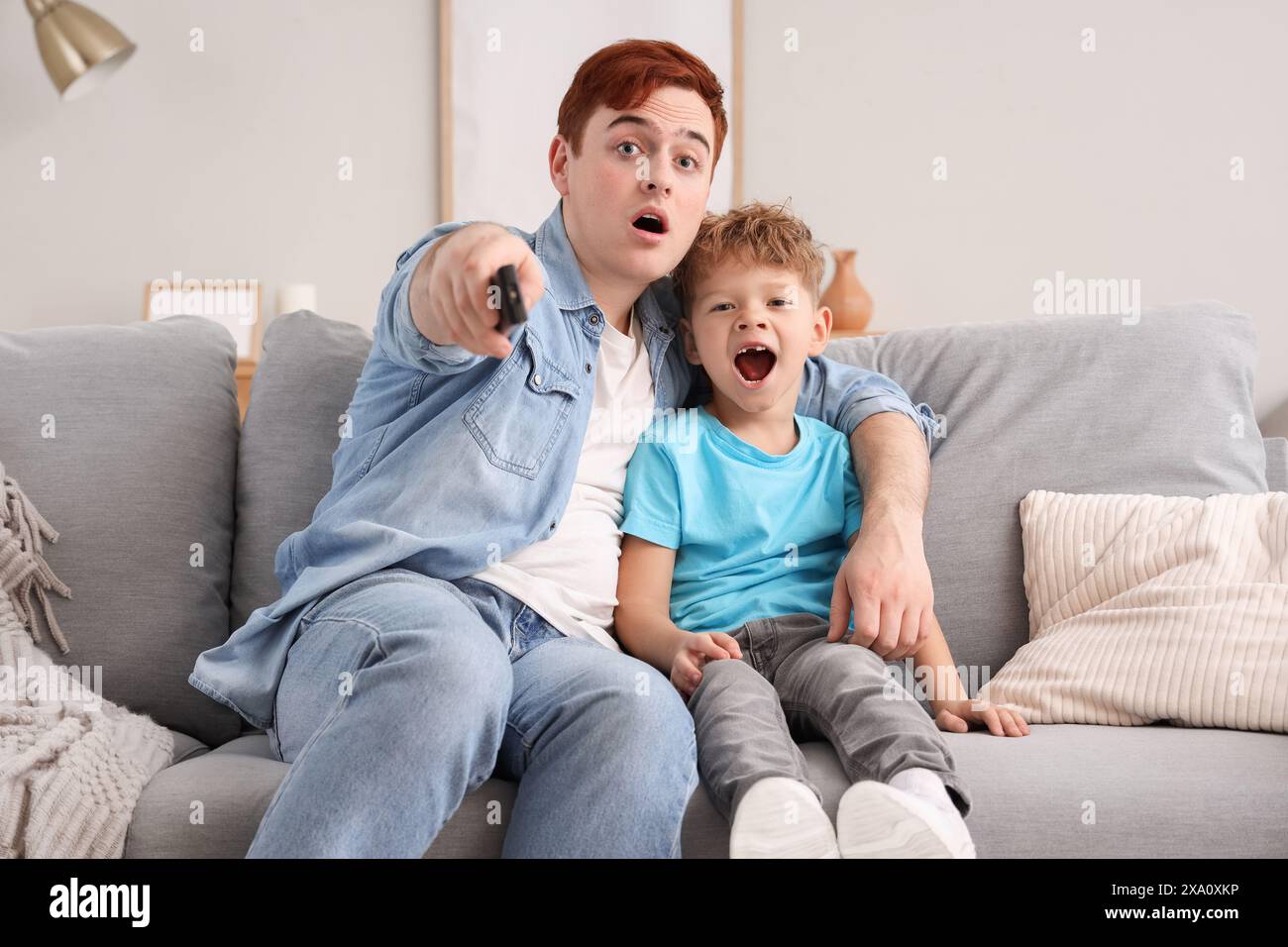 Shocked little boy with his father watching TV at home Stock Photo - Alamy