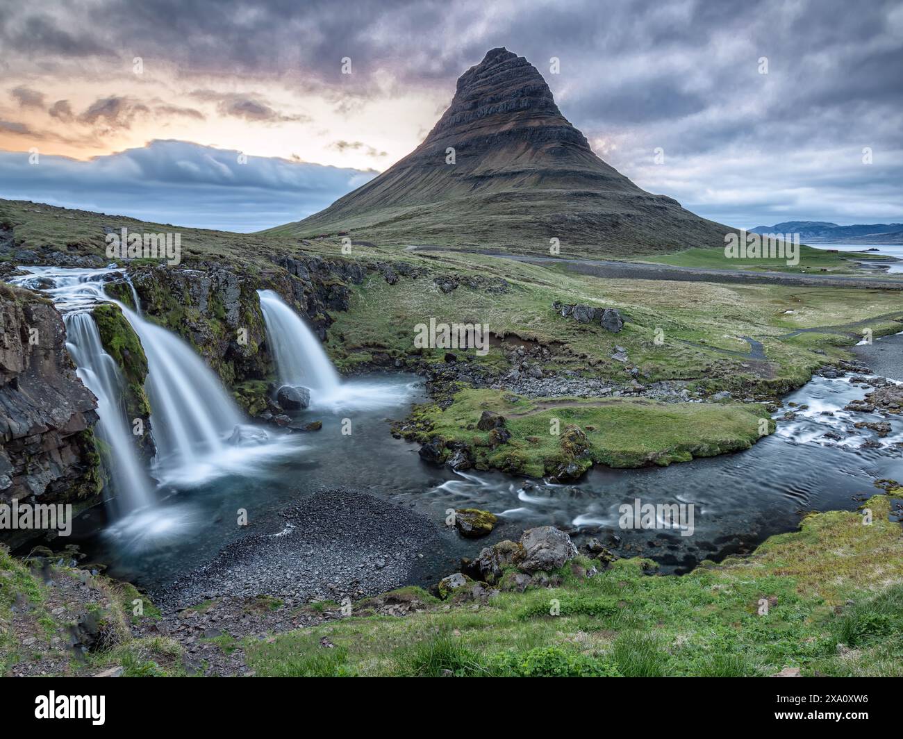 A sunset casting warm light on Kirkjufell waterfall Stock Photo - Alamy