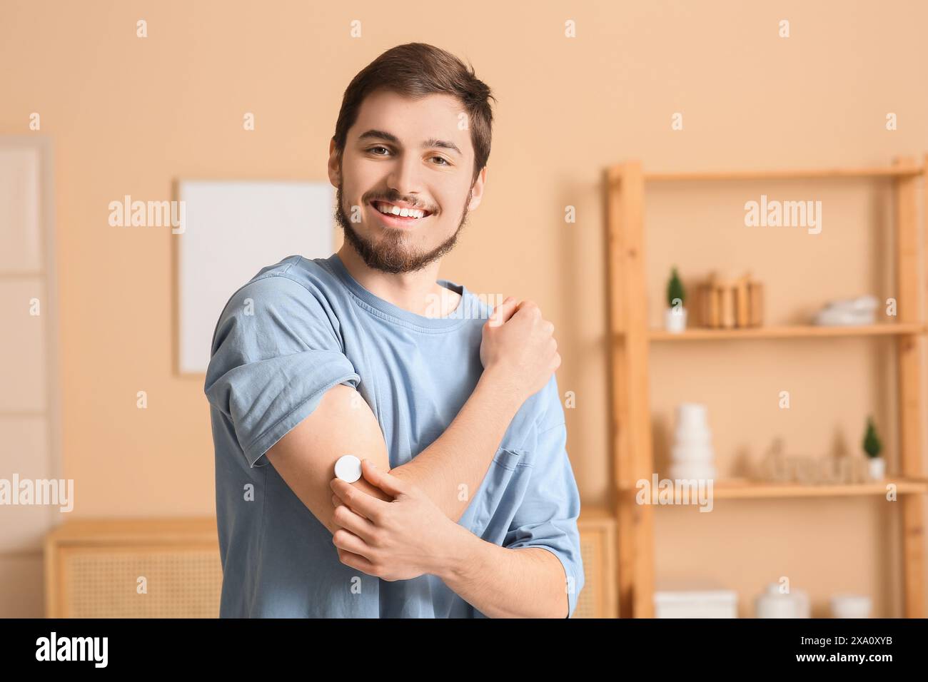 Diabetic young man with glucose sensor at home Stock Photo - Alamy