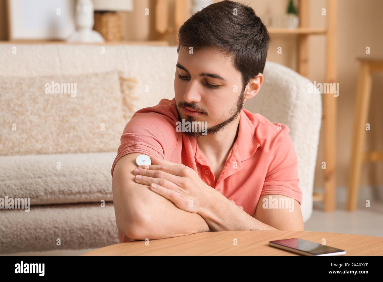 Diabetic young man with glucose sensor at home, closeup Stock Photo - Alamy