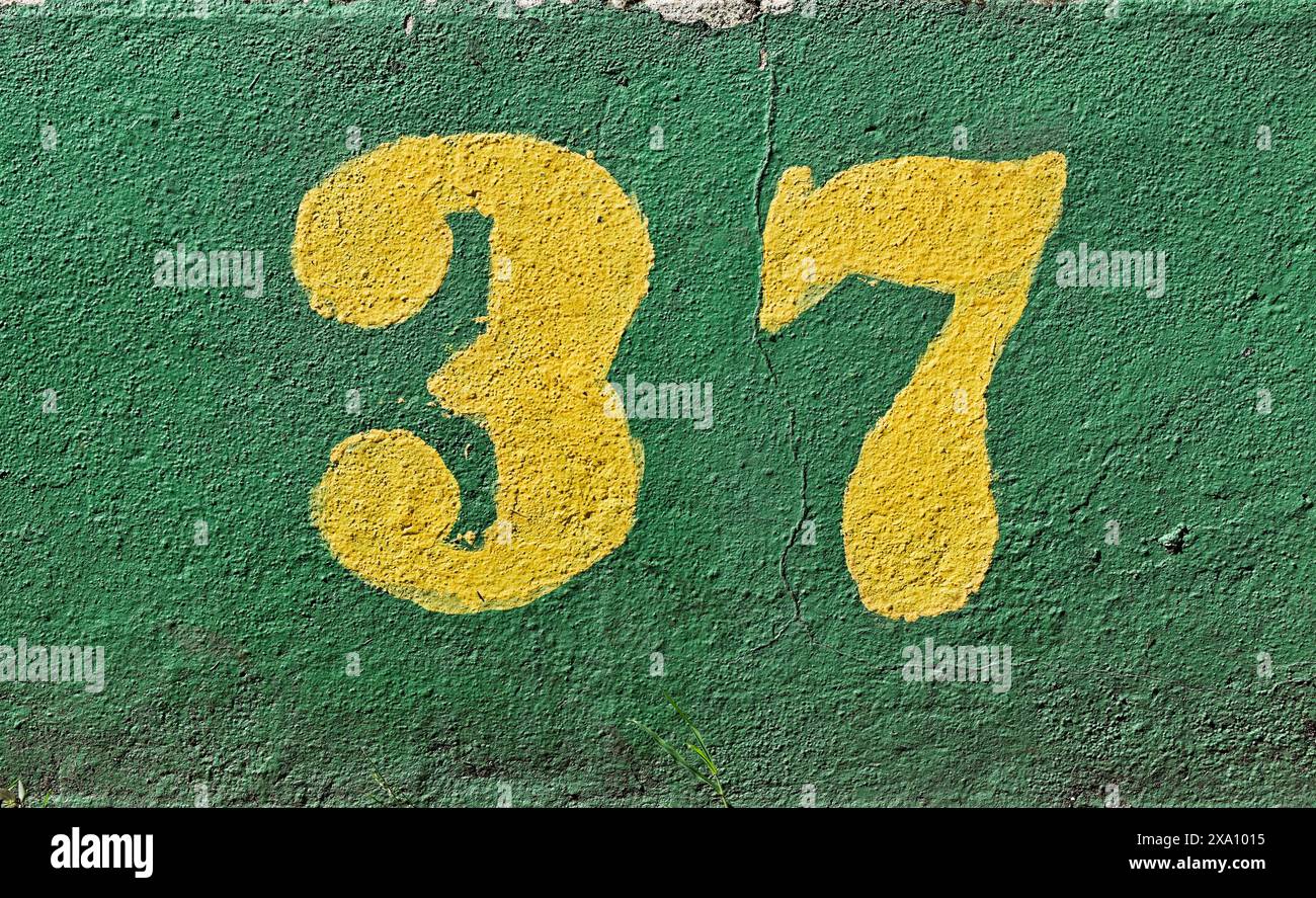 Number 37 painted in yellow on a green wall Stock Photo - Alamy