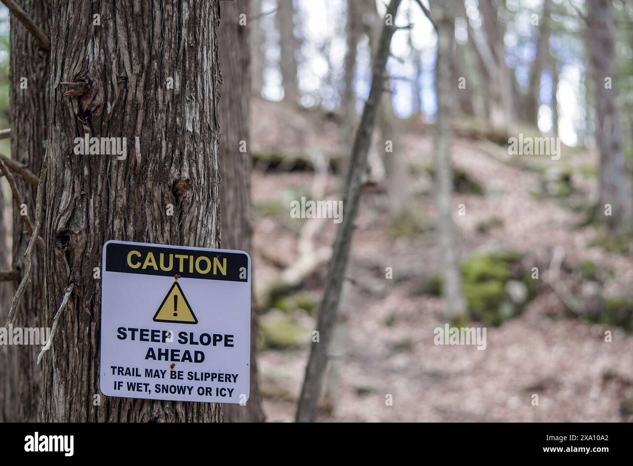 Caution steep slope ahead. A sign on a trail Stock Photo - Alamy