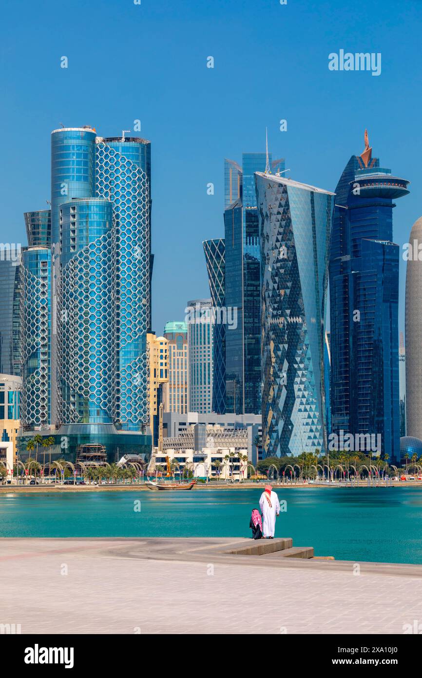 A Man in Traditional Costume with a Dhow against the West Bay Skyline ...