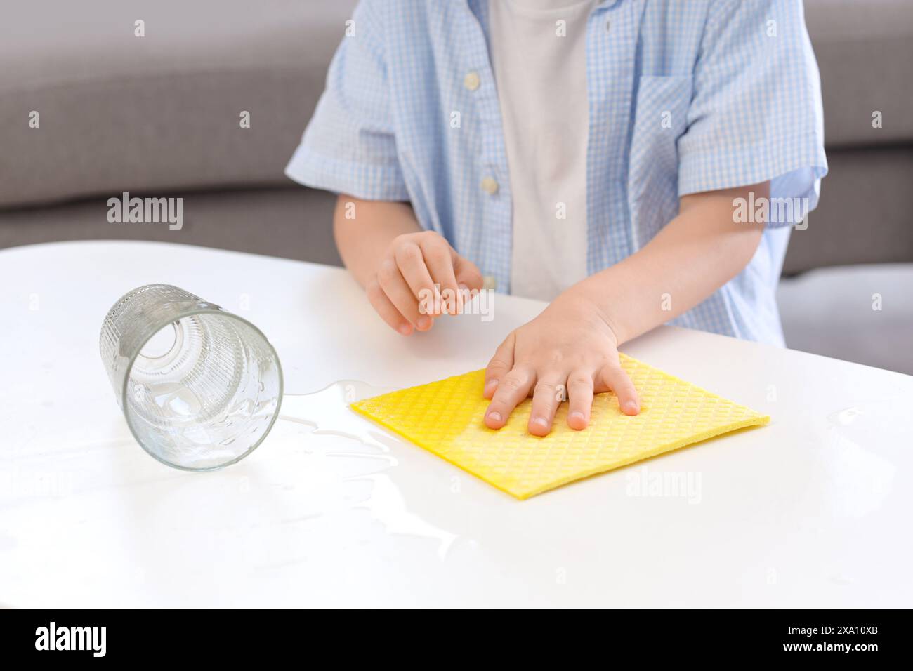 Cute little girl wiping spilled water on table at home, closeup Stock ...