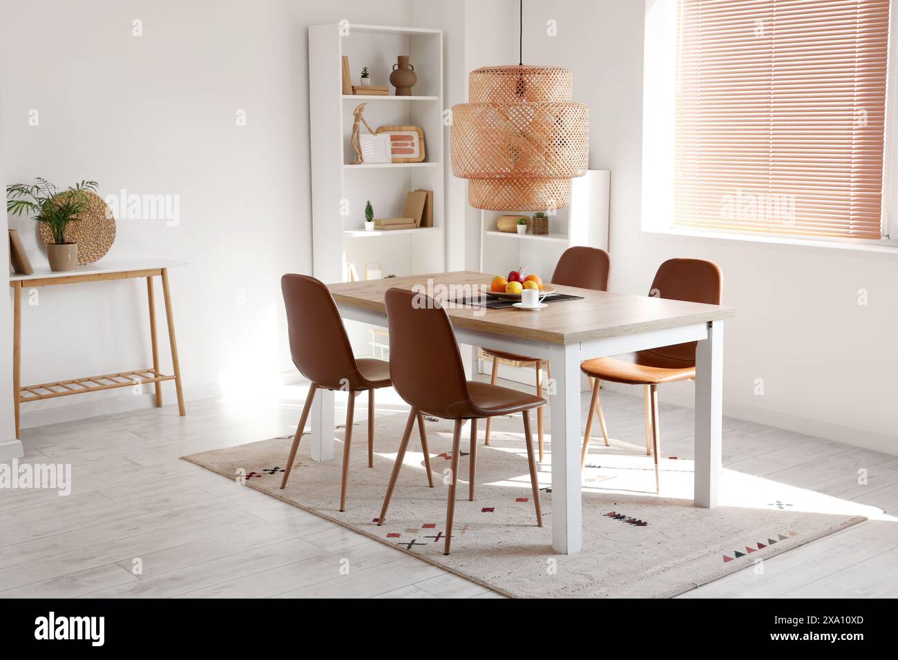 Interior of light room with dining table and shelf units Stock Photo ...