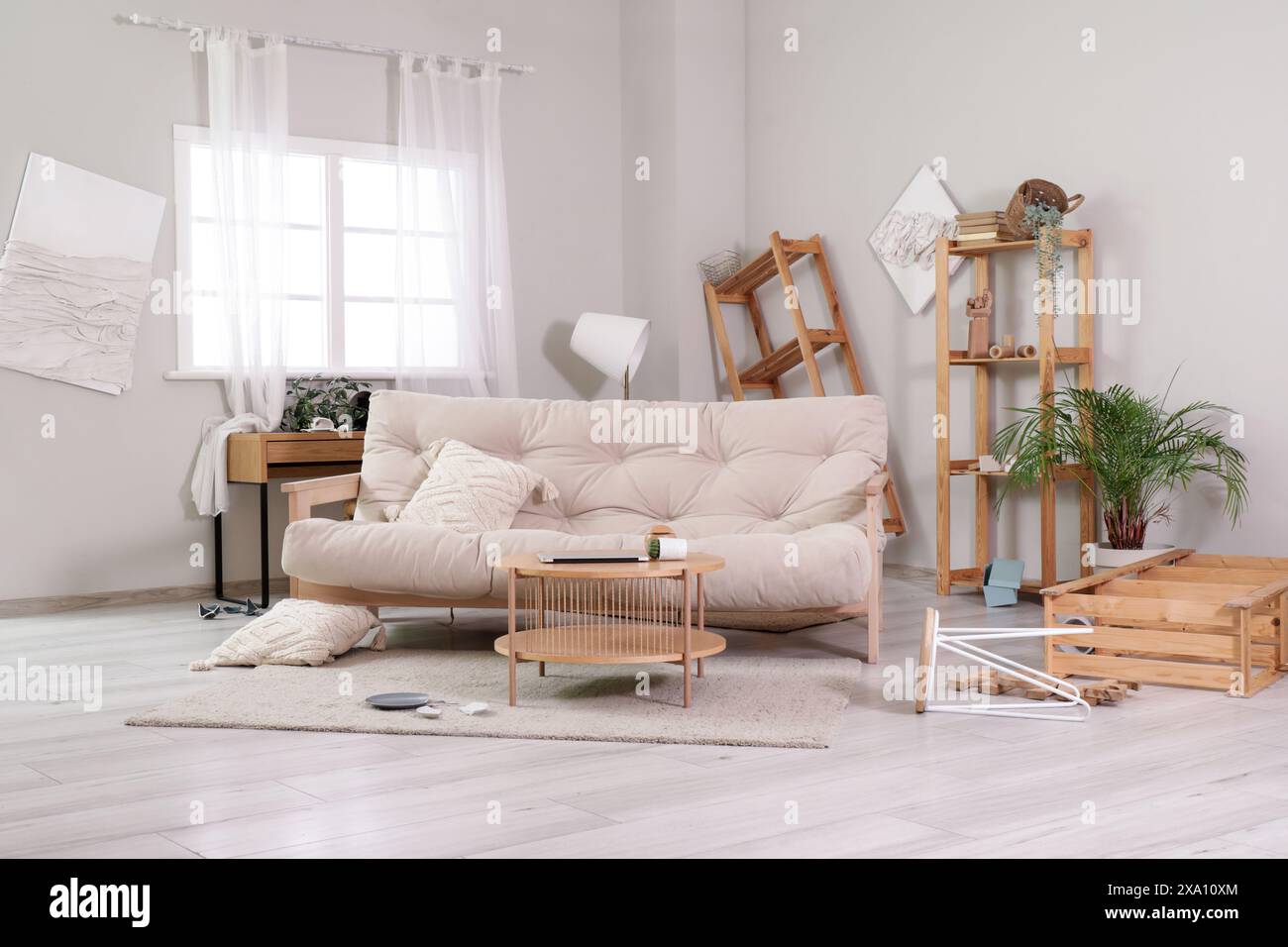 Interior of messy living room with sofa, tables and shelf units Stock ...