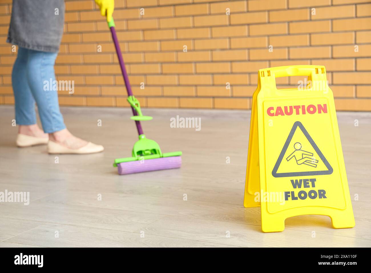 Caution sign and female janitor mopping floor in room, closeup Stock ...