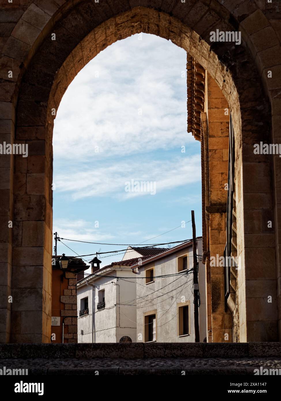 A stone arch next to the houses of the town of Arcas, Cuenca, Spain ...