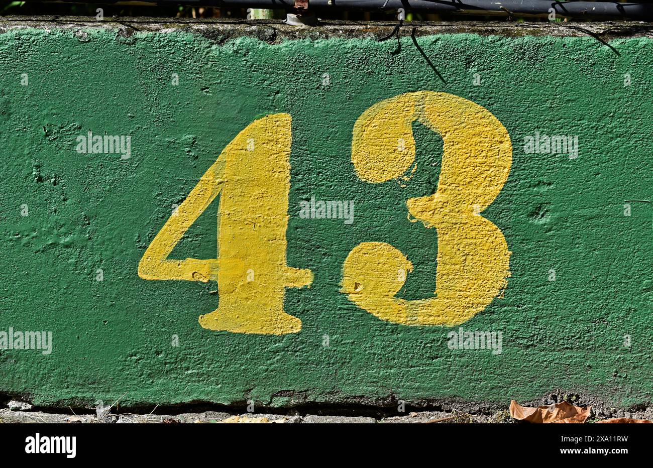 Number 43 painted in yellow on a green wall Stock Photo - Alamy