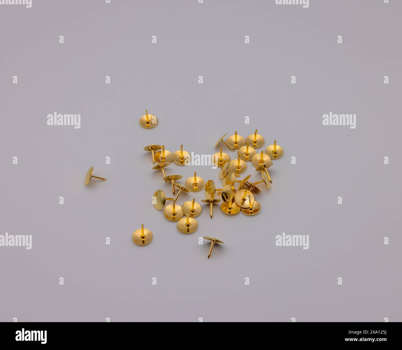 The golden push pins on a grey surface Stock Photo - Alamy