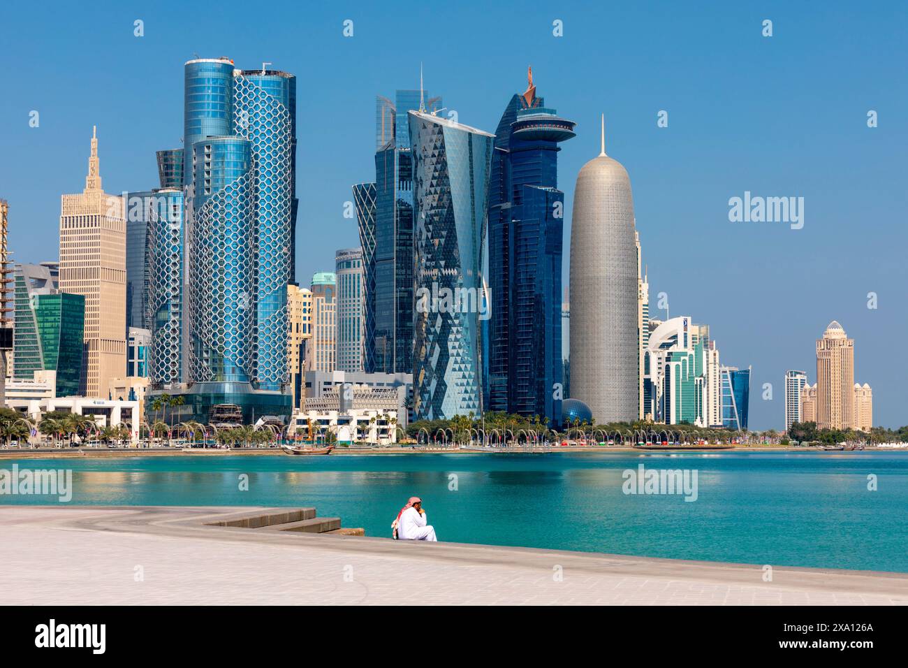 A Man in Traditional Costume with a Dhow against the West Bay Skyline ...