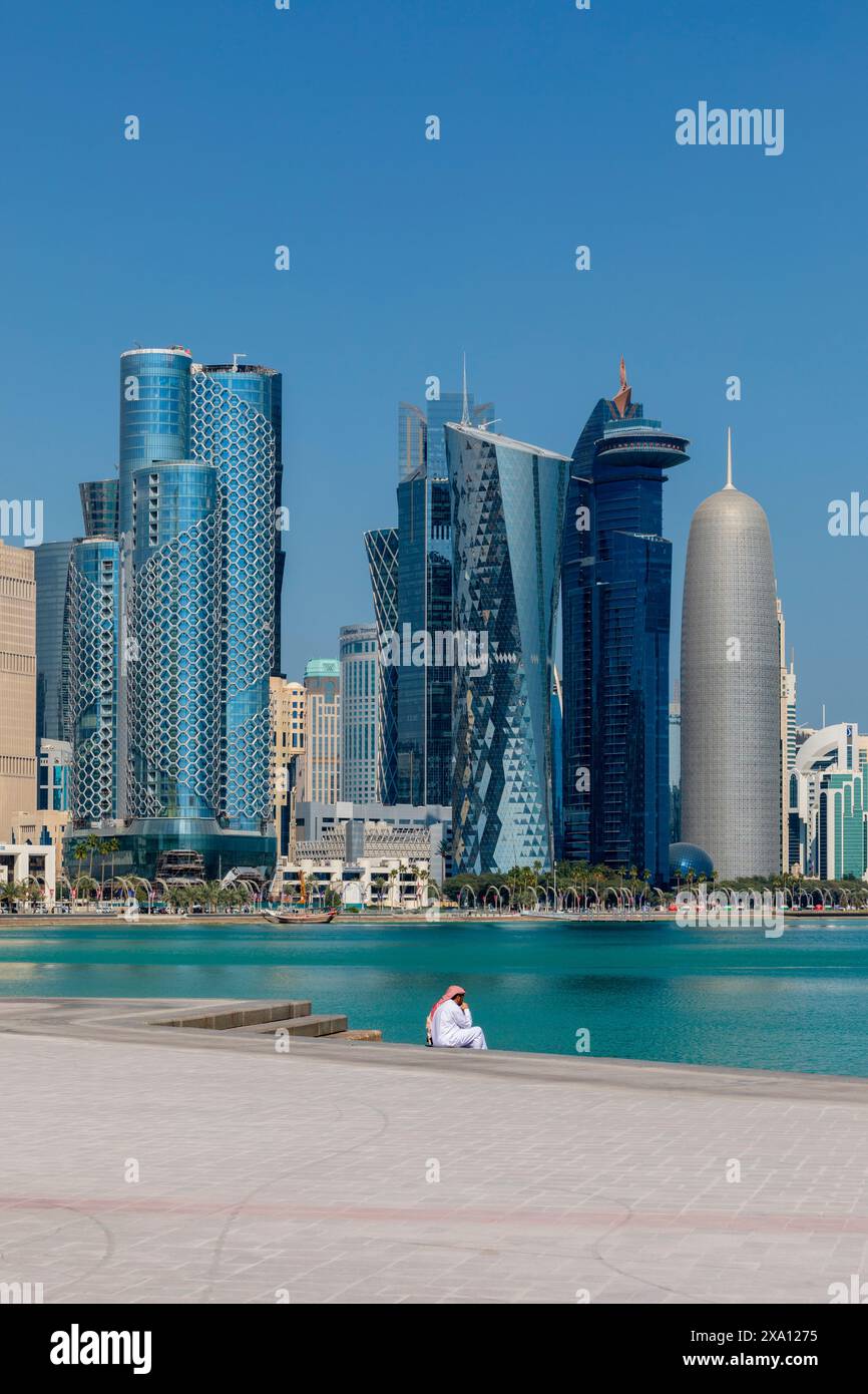 A Man in Traditional Costume with a Dhow against the West Bay Skyline ...