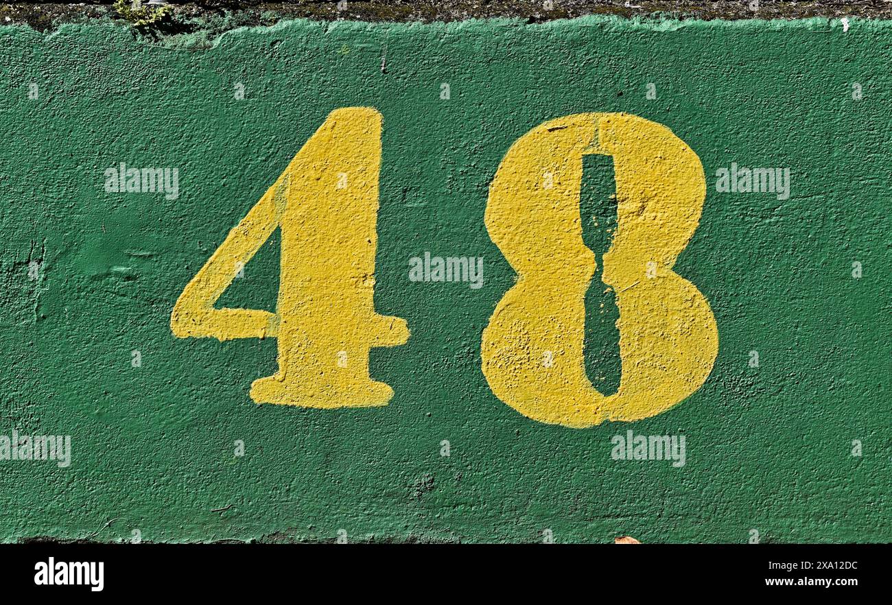 Number 48 painted in yellow on a green wall Stock Photo - Alamy
