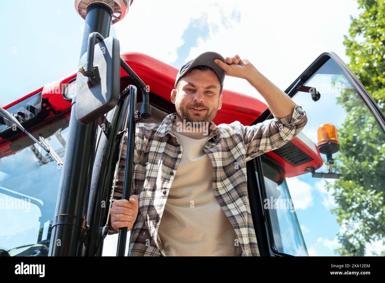 Low angle view portrait of man tractor driver. Farmer and agricultural ...