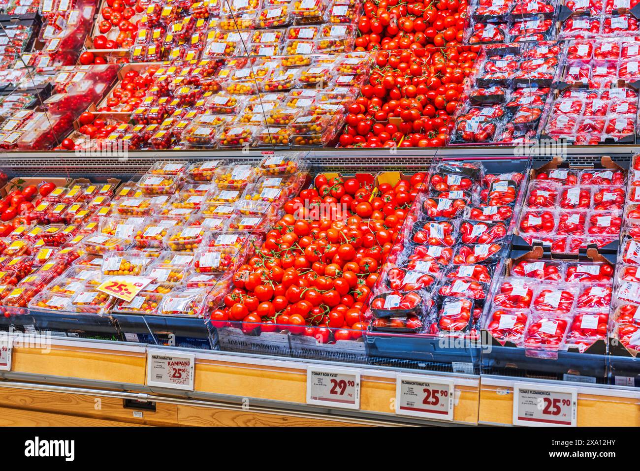 Close-up view of shelves with various types of tomatoes on display in ...