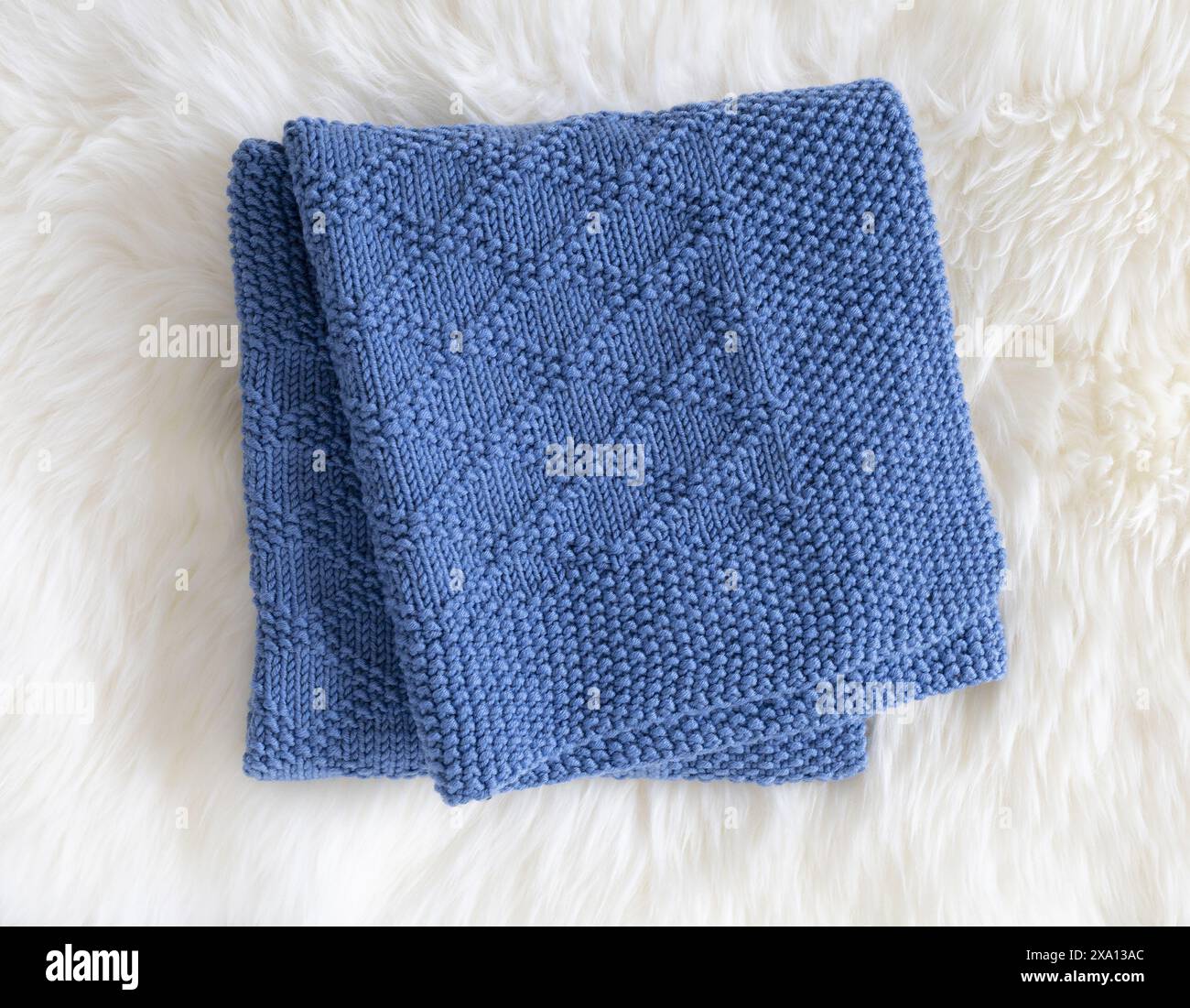 Flat lay photography of a navy blue knitted blanket in brocade knitting ...