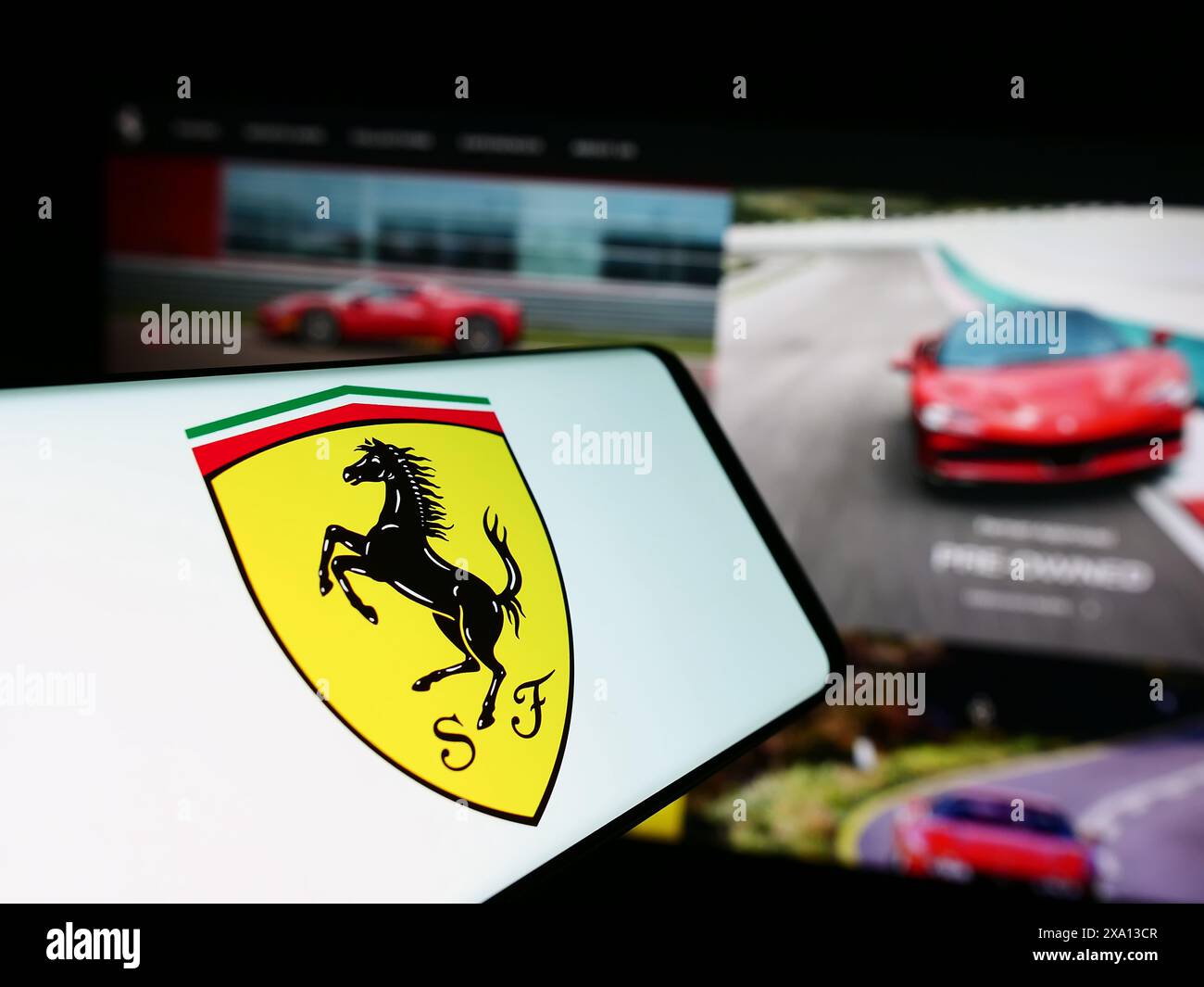 Smartphone with logo of Italian sports car company Ferrari SpA in front ...