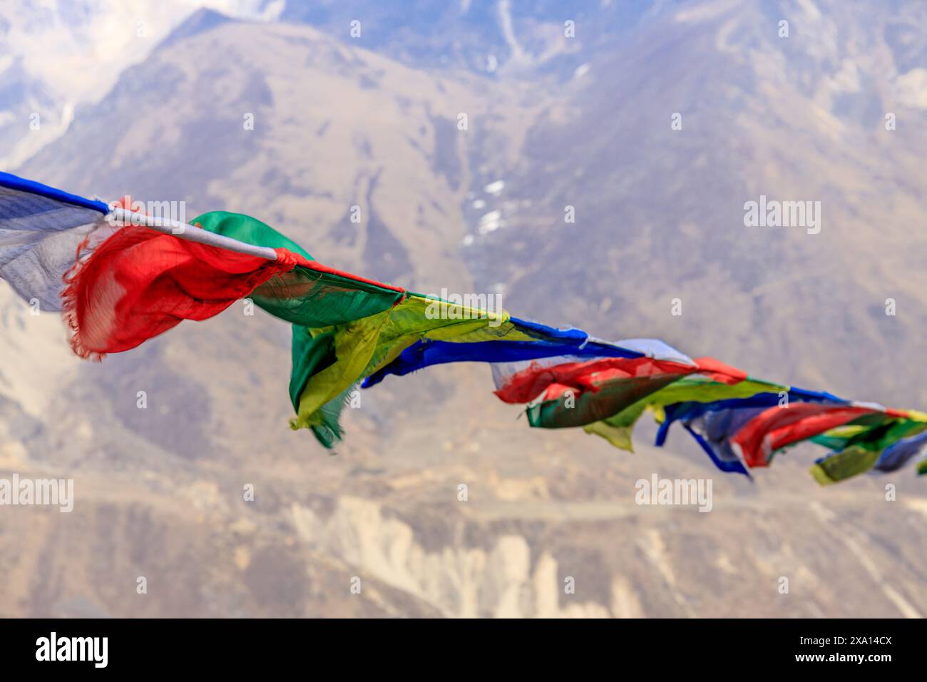 Colorful Nepali and Tibetan prayer flags fluttering in the majestic mountains of Nepal ...
