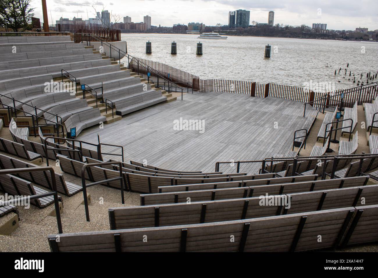 An outdoor concert seating by water with city skyline in the background ...