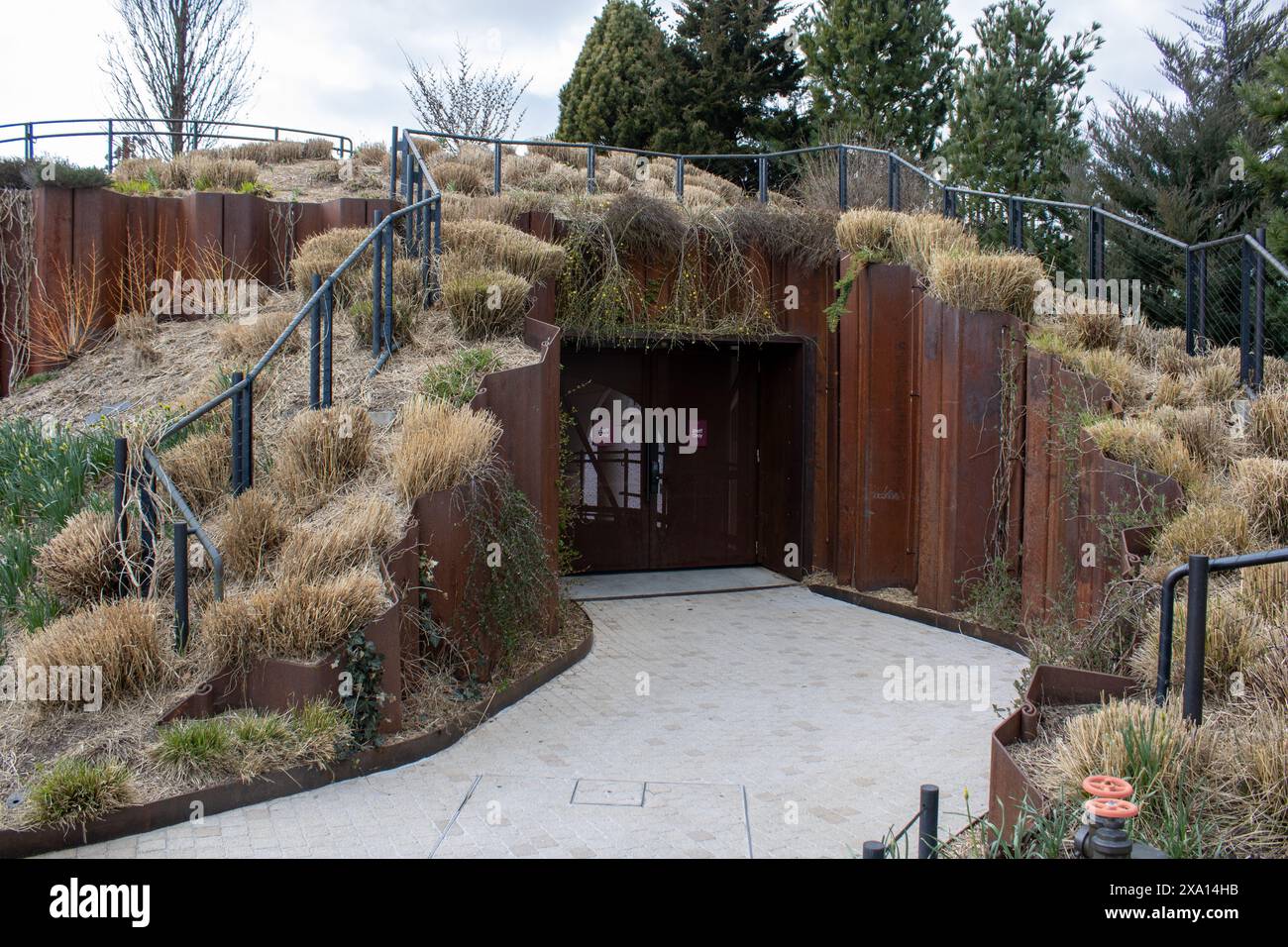 An underground passage with metal stairs leading to a building covered ...