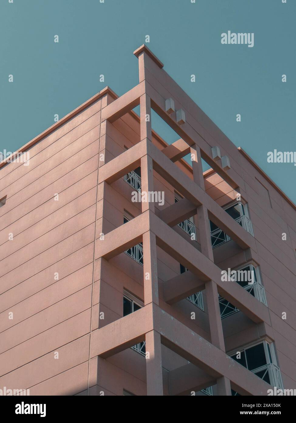 A beige building with windows and a clock on the side Stock Photo - Alamy