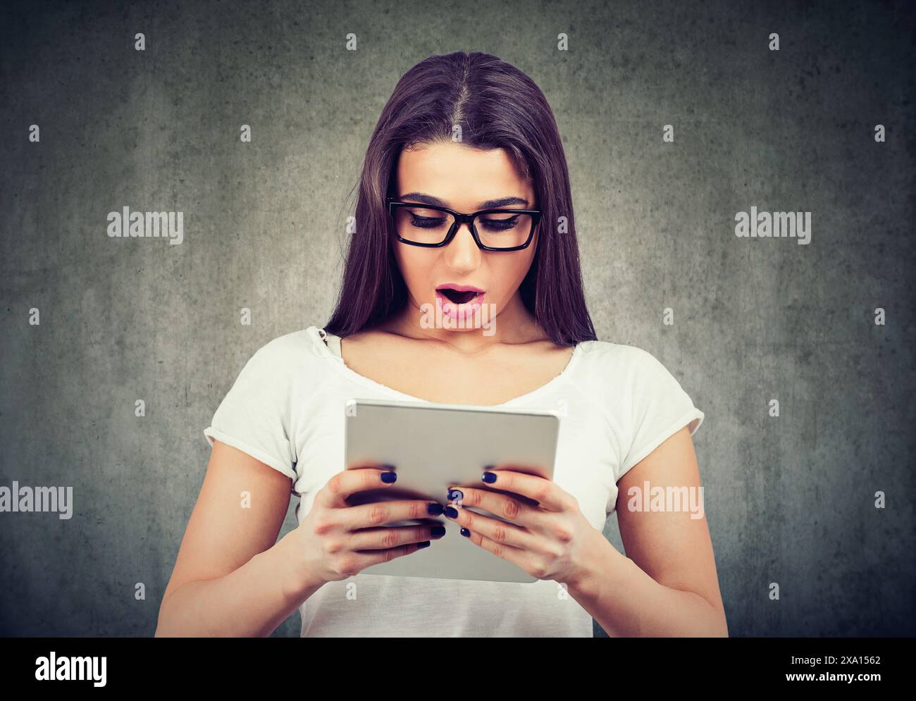 portrait of a shocked woman in glasses reading email on her tablet ...