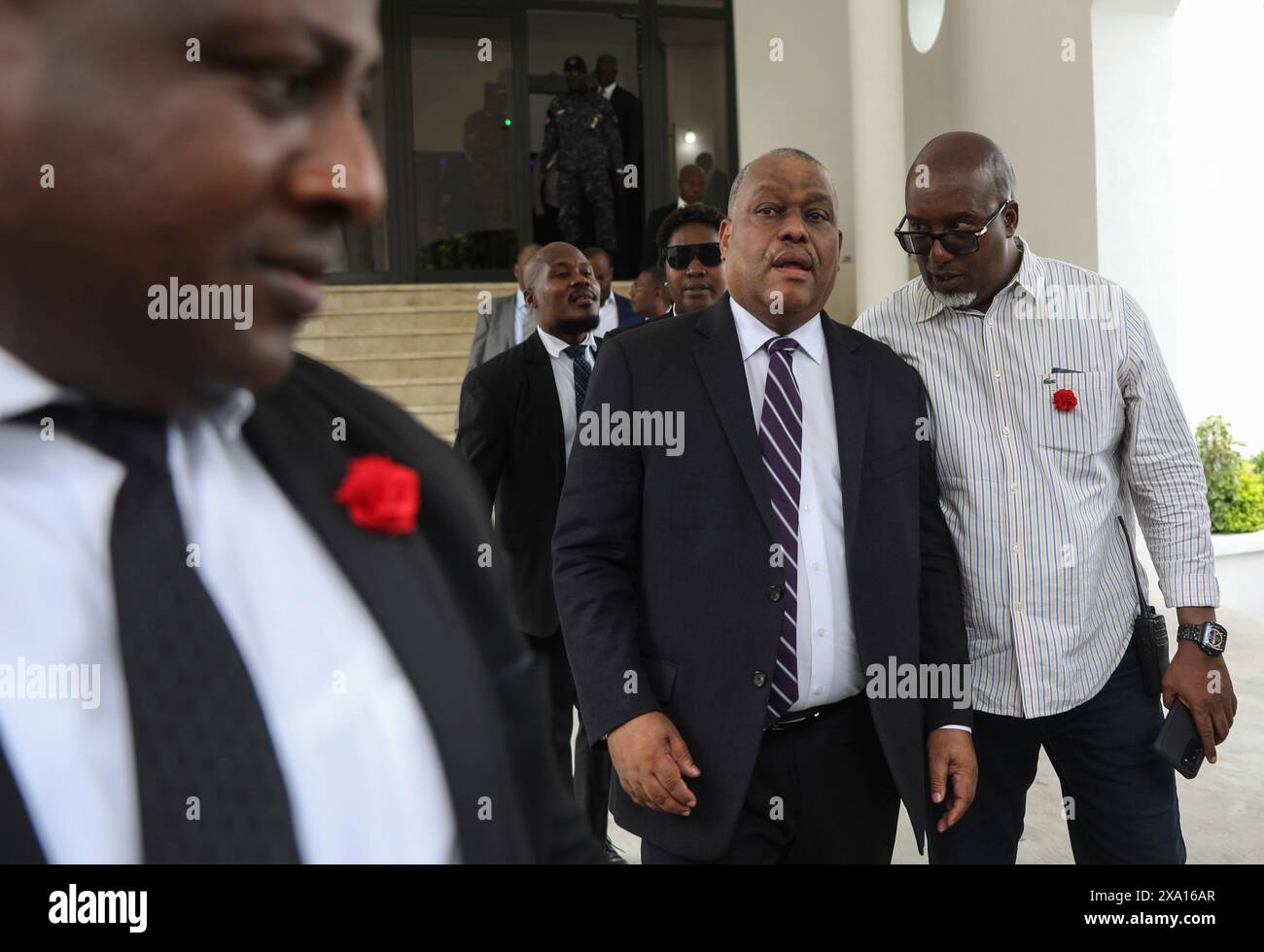 Garry Conille, center, leaves his swearing-in ceremony as prime ...
