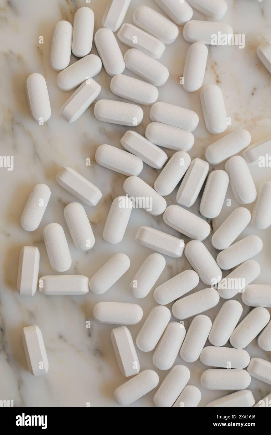 scattered white calcium vitamin pills on white marble Stock Photo - Alamy