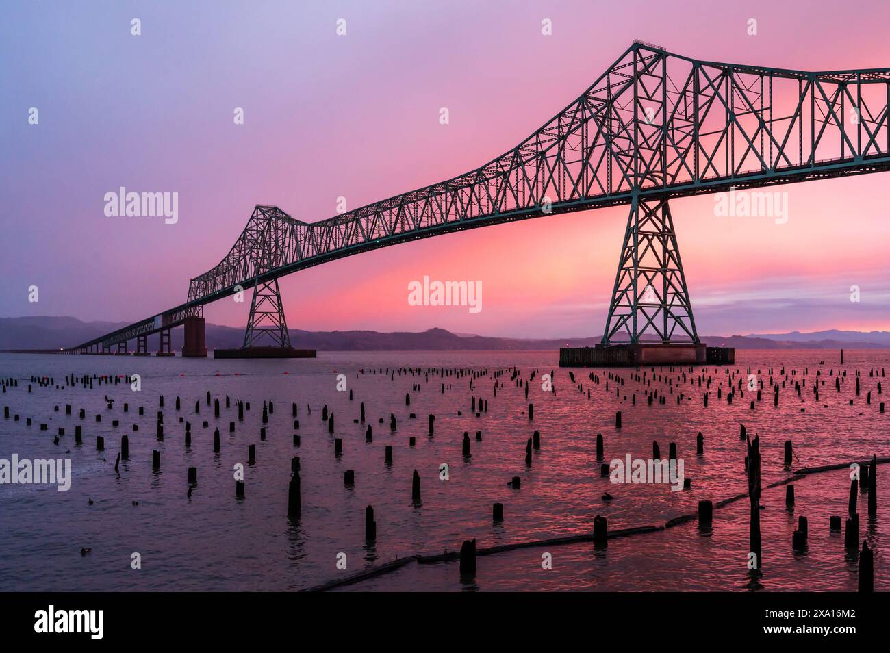 A scenic view of Astoria-Megler Bridge silhouetted against a colorful ...