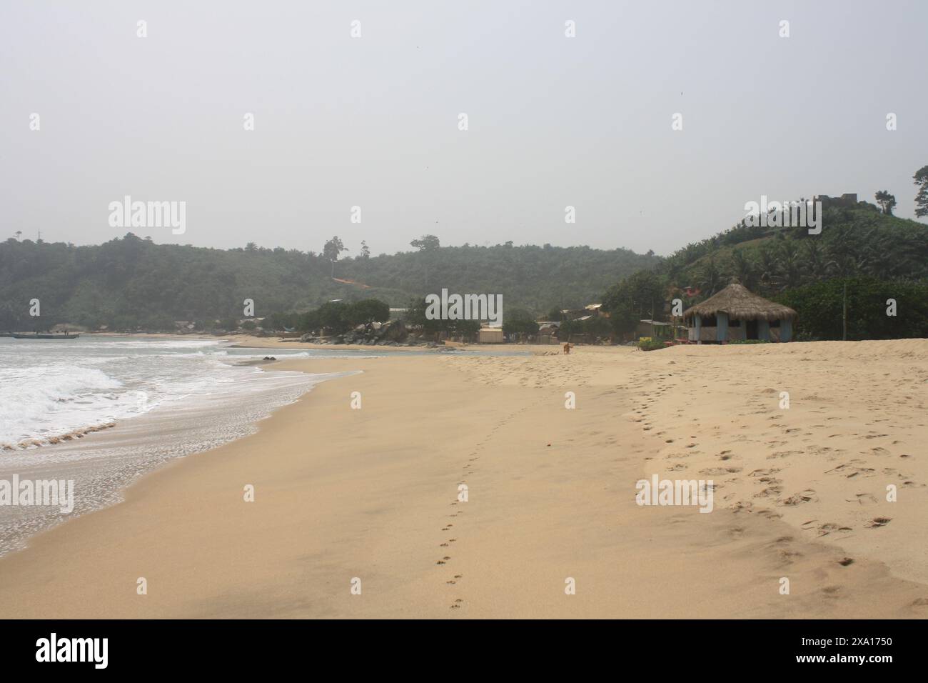 An expansive beach with gentle waves washing ashore and footprints ...