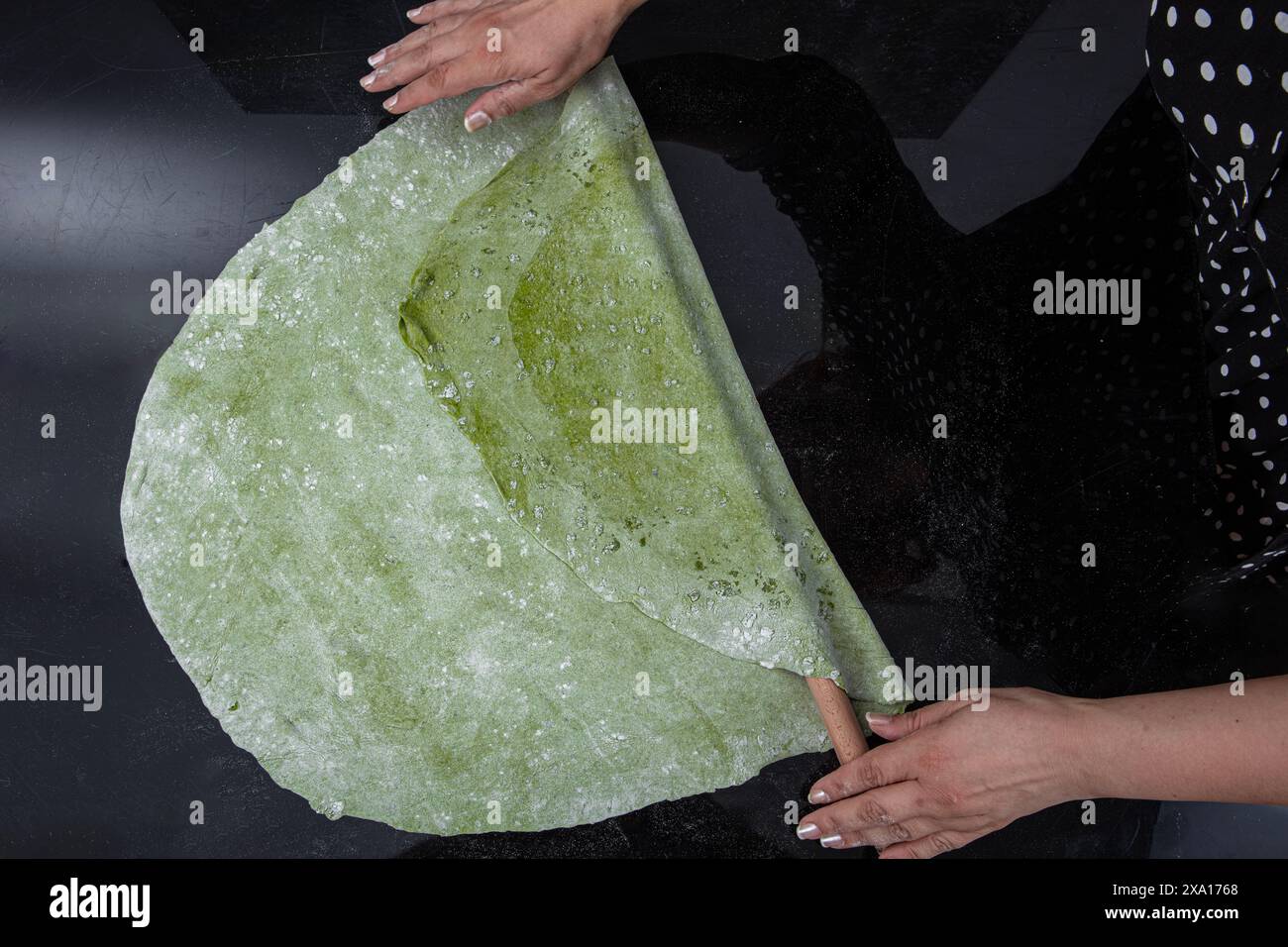Green Pasta with Spinach. Pasta with spinach. Female chef rolls out ...