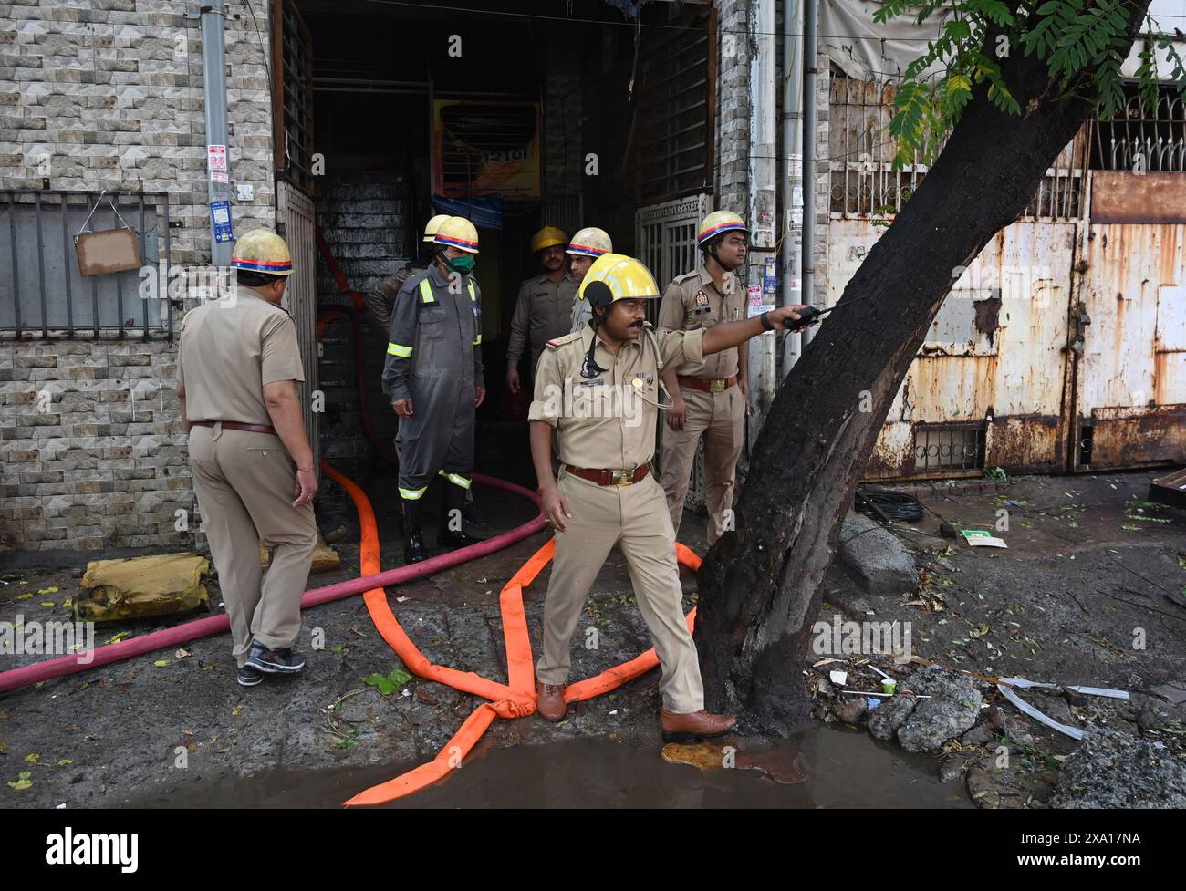 NOIDA, INDIA - JUNE 3: Fire brigade personnel extinguish the fire at a garment factory in Sector ...