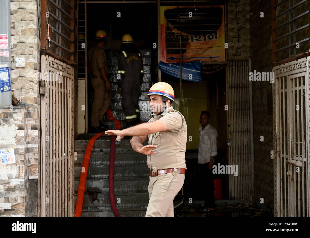 NOIDA, INDIA - JUNE 3: Fire brigade personnel extinguish the fire at a garment factory in Sector ...