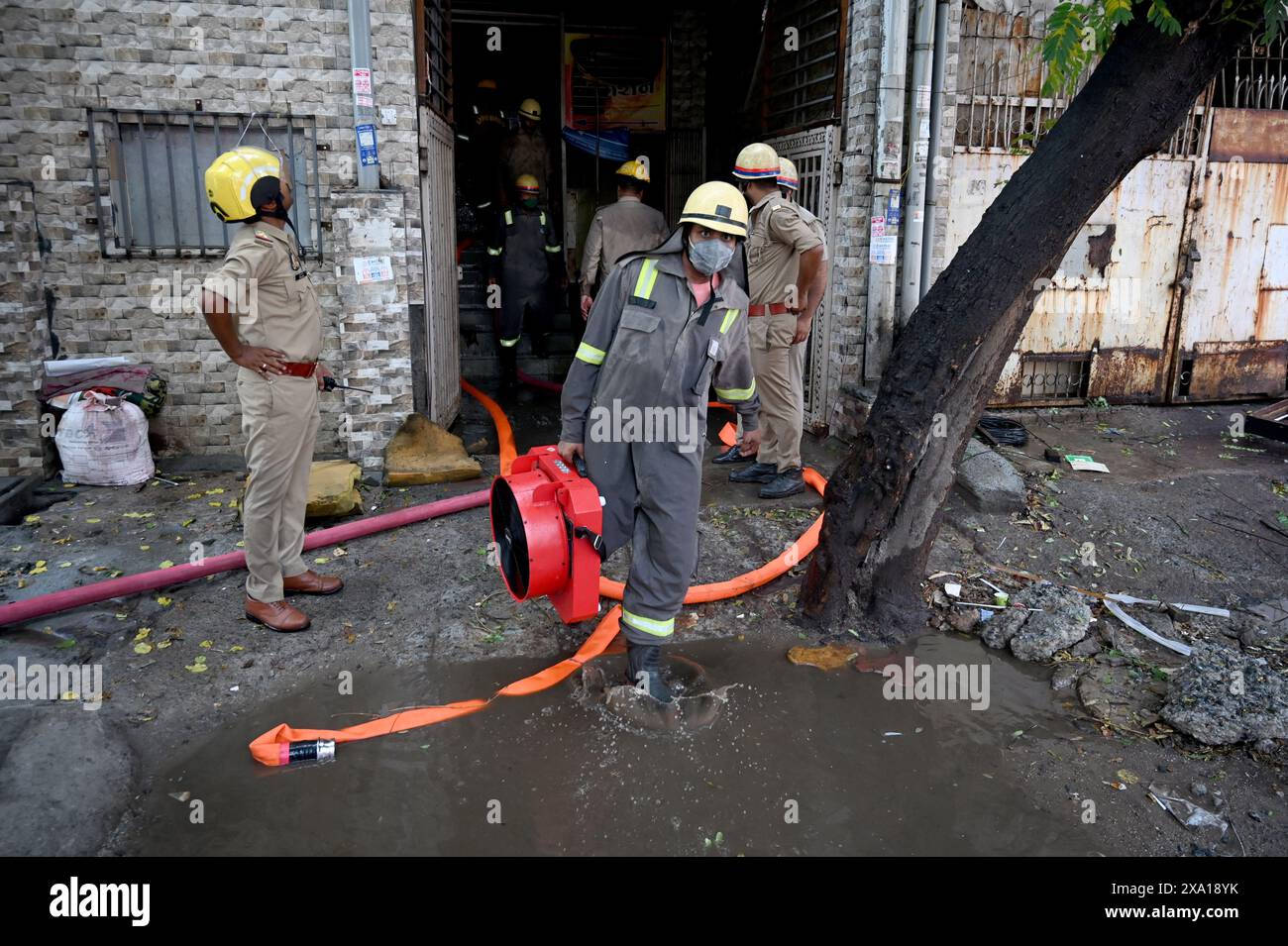 NOIDA, INDIA - JUNE 3: Fire brigade personnel extinguish the fire at a garment factory in Sector ...
