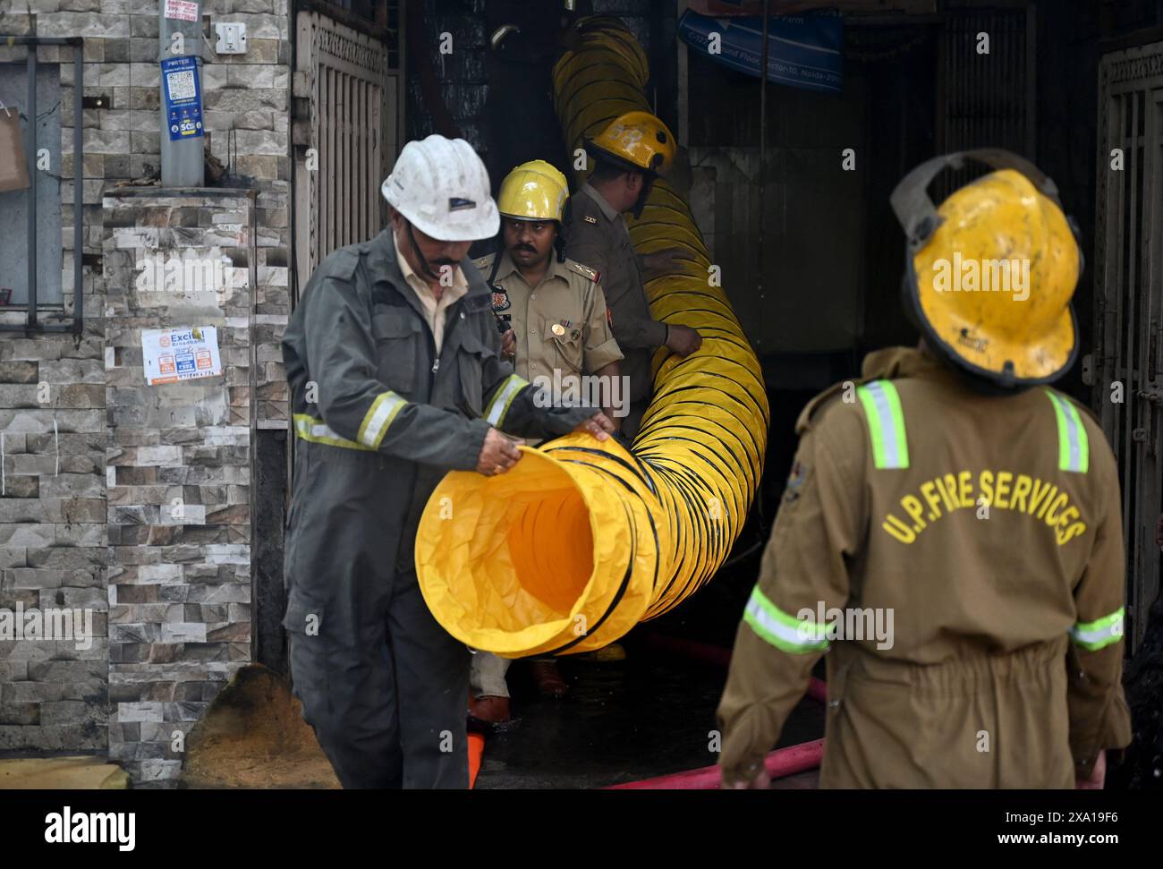 NOIDA, INDIA - JUNE 3: Fire brigade personnel extinguish the fire at a garment factory in Sector ...