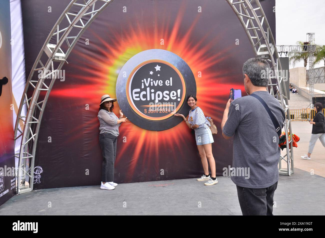 Group of three individuals photographing in front of a solar eclipse ...