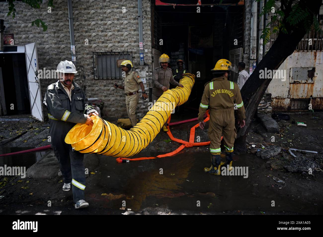 NOIDA, INDIA - JUNE 3: Fire brigade personnel extinguish the fire at a garment factory in Sector ...